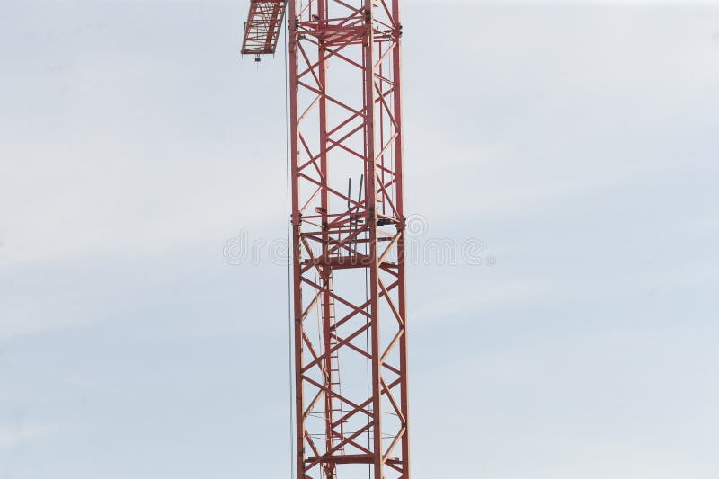 A Large Red Construction Crane Stands Tall Against a Cloudy Sky Stock ...