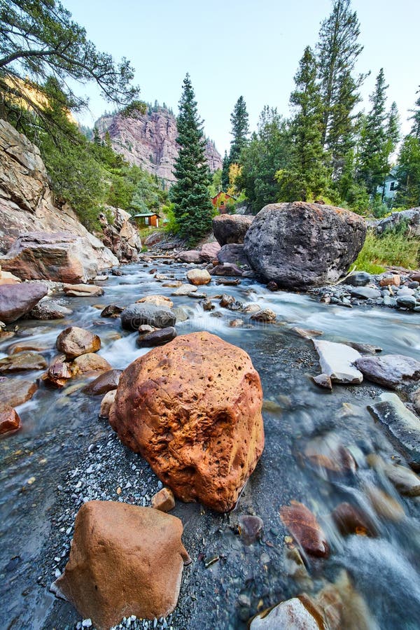 Large Red Rock in Clear Shallow Riverbed with Mountain in Distance ...