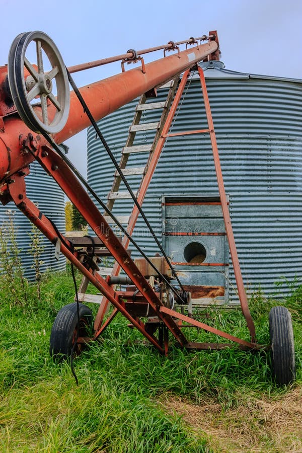 A Large Red and Silver Grain Silo with a Ladder on Top Stock Photo ...