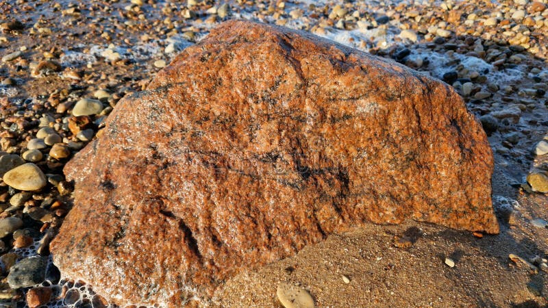 Large Reddish Rock on a Sandy Beach Stock Image - Image of rough, rock ...