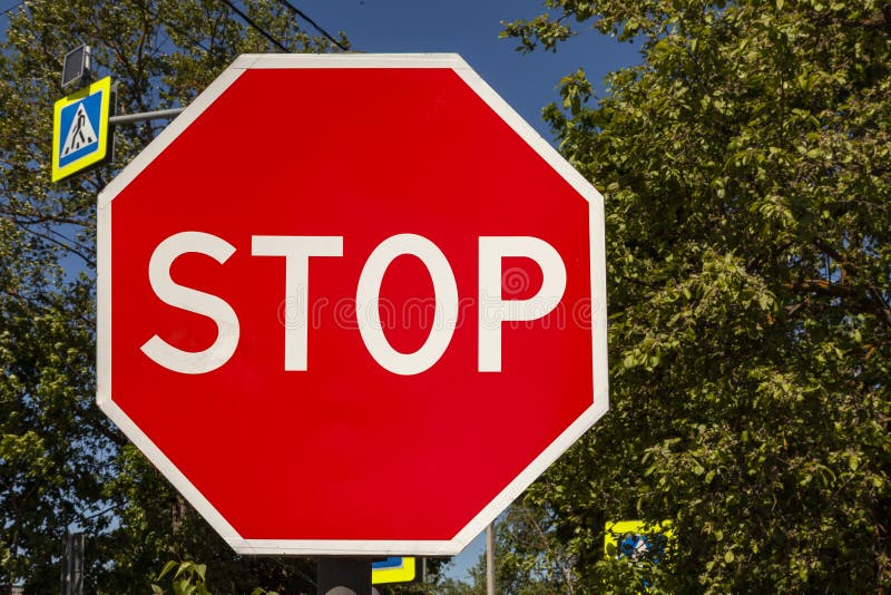 Large Road Sign Stop Against the Background of Green Trees and Blue Sky ...