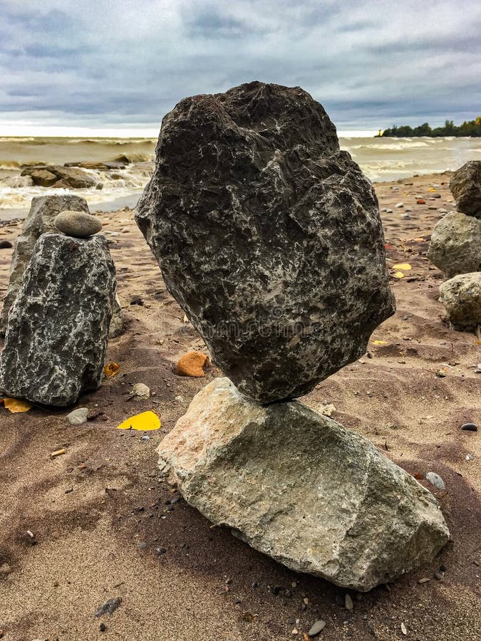 A Large Rock Balanced on Another at a Beach Under Stormy Sky and ...