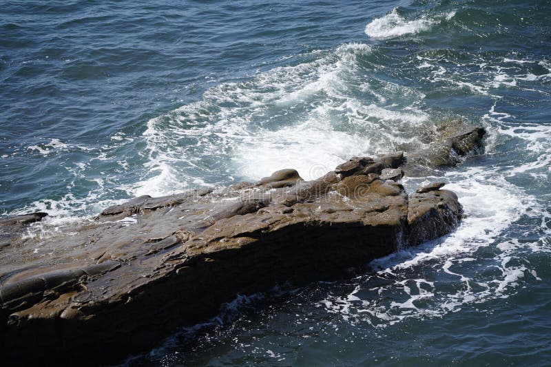 Large Rock Formation in the Middle of an Expansive Body of Blue Water ...