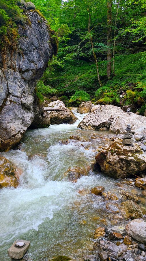A Rock Overhangs a Mountain Stream in a Canyon Against a Forest ...
