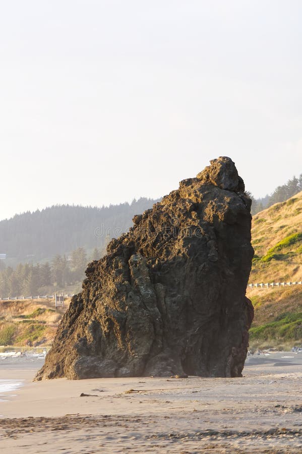 Large Rock on Sand Beach Oregon with Hills in Background Stock Image ...