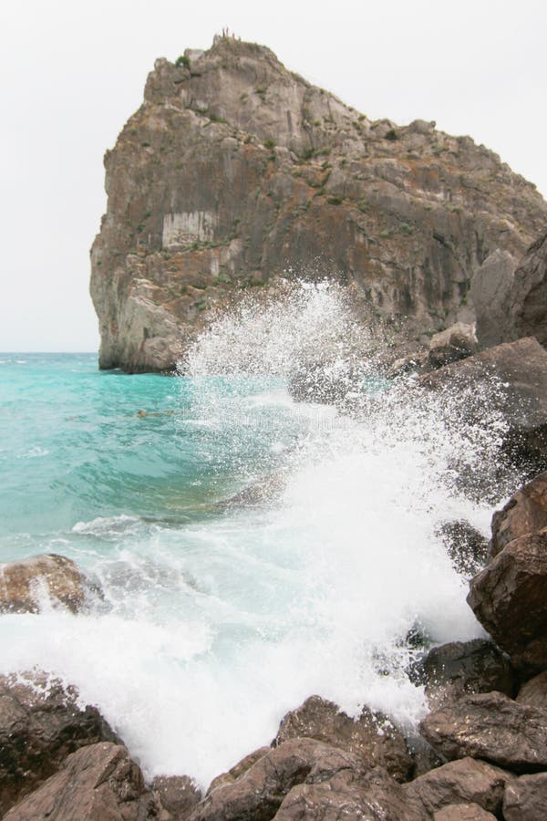 A Large Rock on a Sea Beach in the Surf. Sea Waves Crash on the Rocks ...