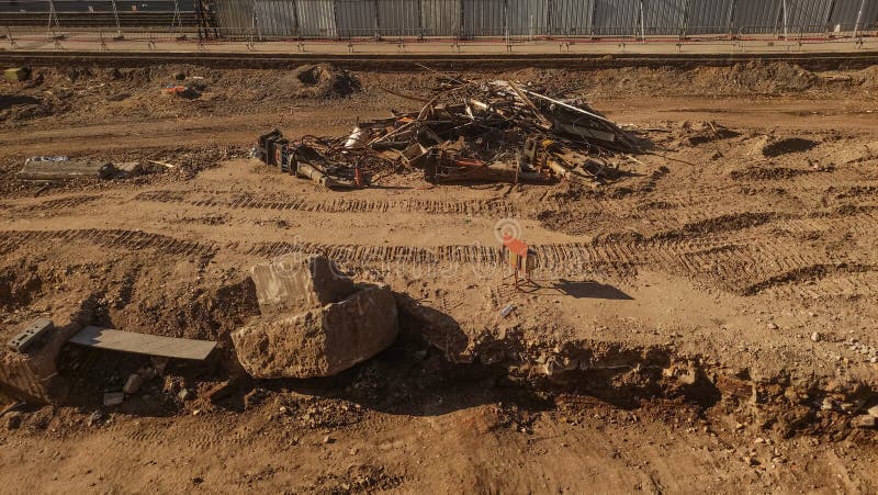 A Large Rock Sits in a Dirt Construction Site with Debris and Tire ...