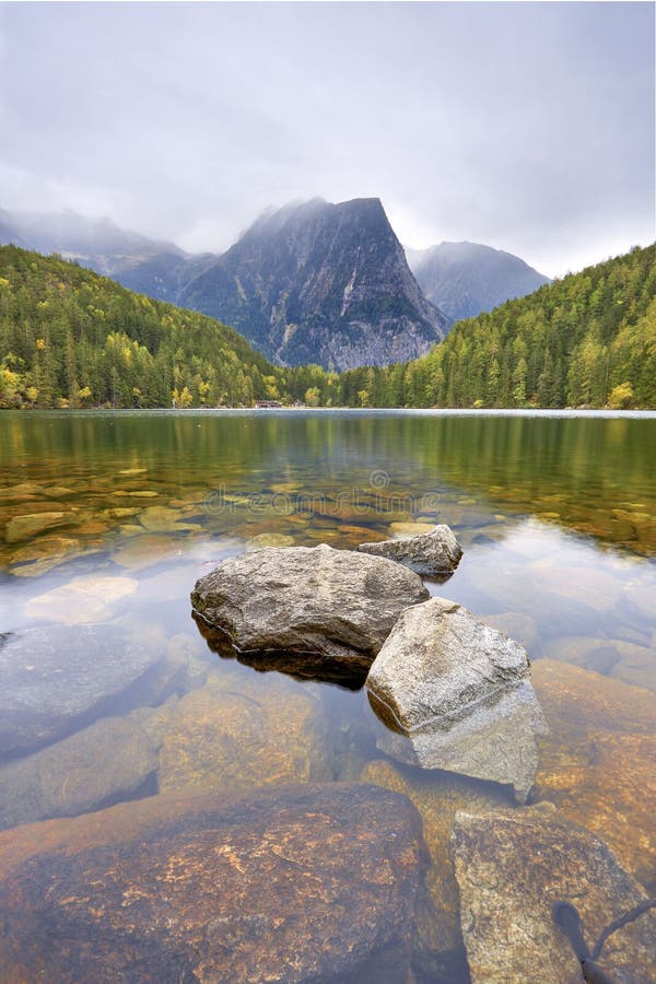 Large Rocks in a Clear Lake with Large Mountains Stock Image - Image of ...