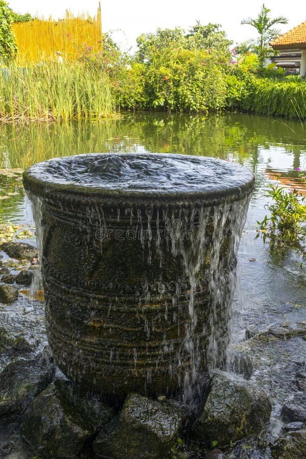 Large, Round, Black Container with Water Pouring Out of it Stock Photo ...