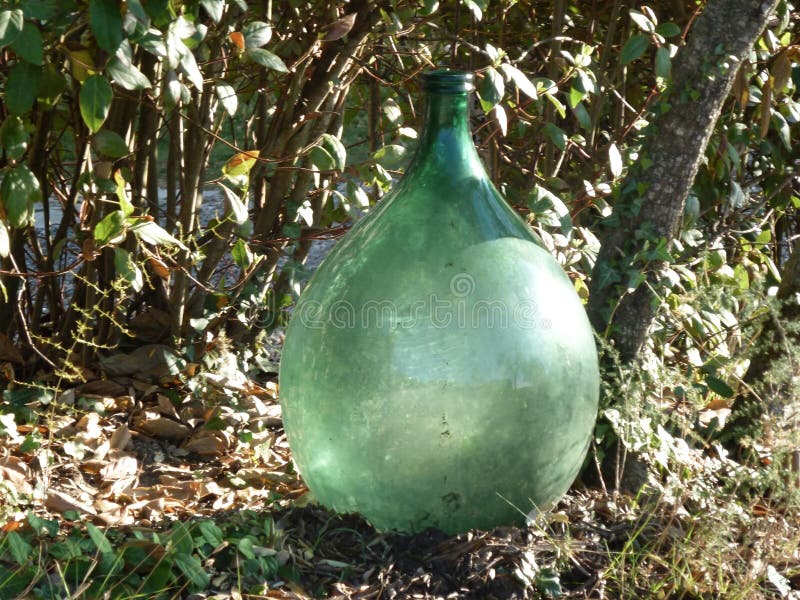 A Large Round Empty Glass Bottle for Winemaking Lies on the Grass in ...