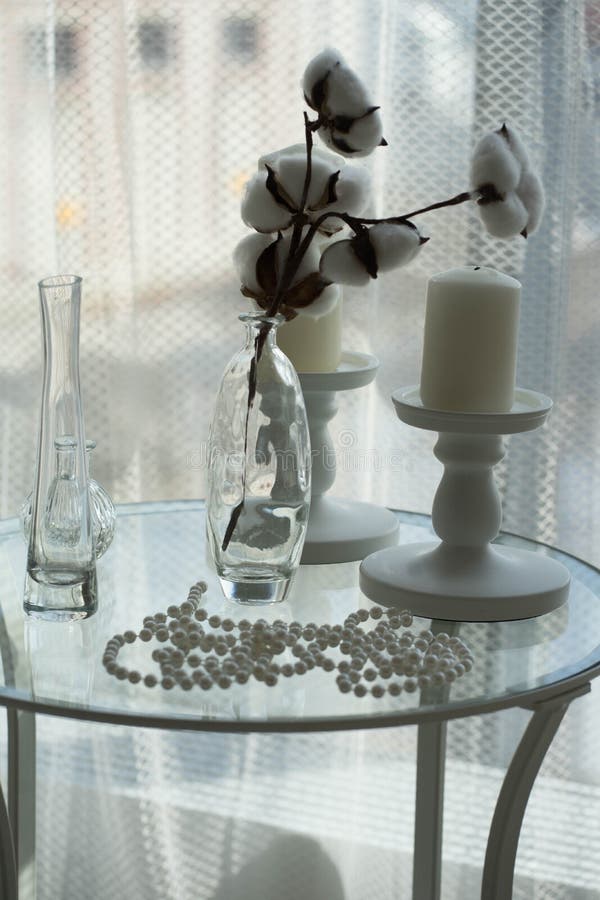 A Large Round Glass Table Stands by the Window with a Vase Stock Photo ...