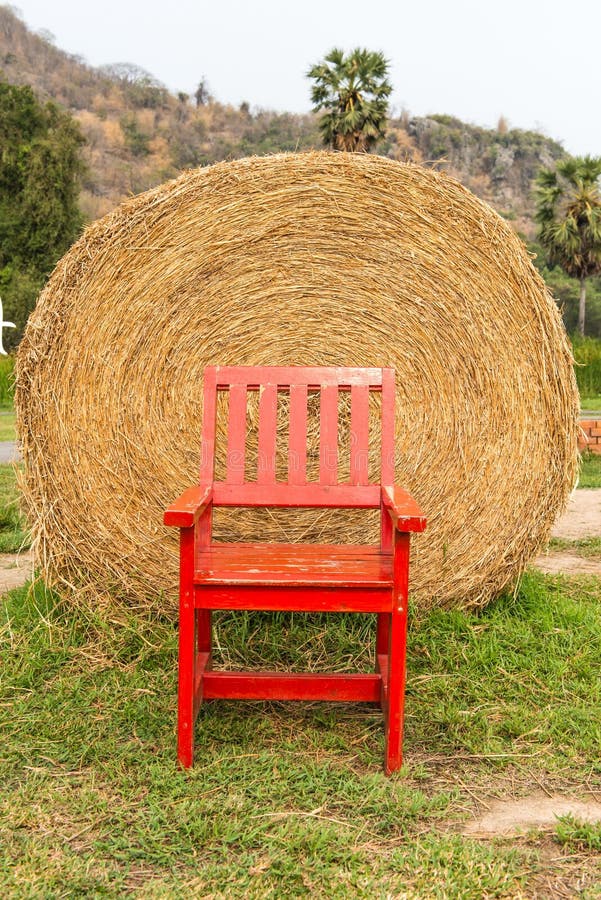 Large Rounded Hay Stack on Green Grass with Red Chair Stock Photo ...