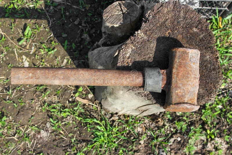 A Large Rusty Sledgehammer on a Wooden Stump Stock Photo - Image of ...