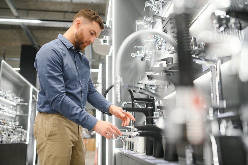 A Large Selection of Water Faucets. Man Chooses a Products in a ...