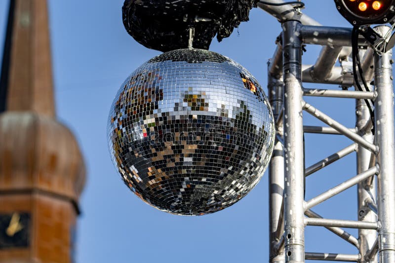 A Large Silver Ball with a Mirror on it is Suspended from a Metal ...