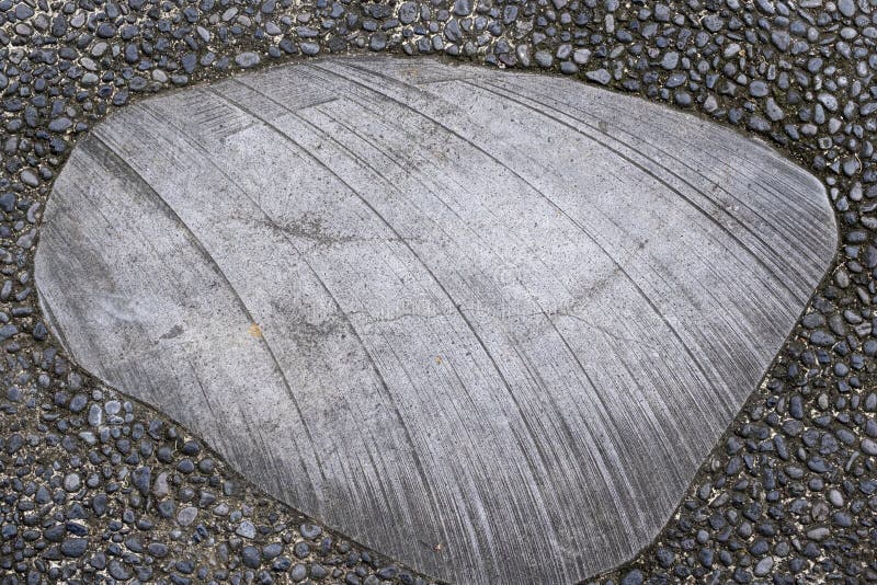 Smooth Gray Stone with Lines on a Gravel Pavement and Dirt Stock Photo ...