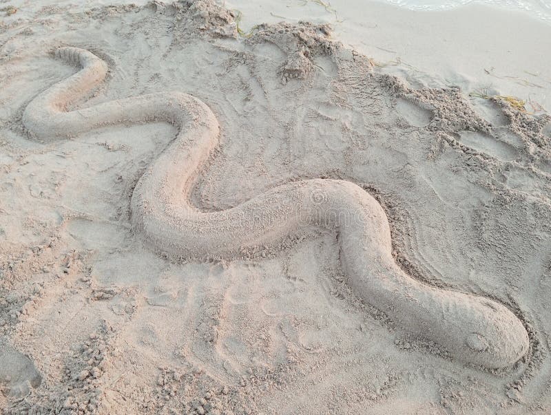 A Large Snake in the Sand of the Sea. Sand Art on the Beach Stock Photo ...