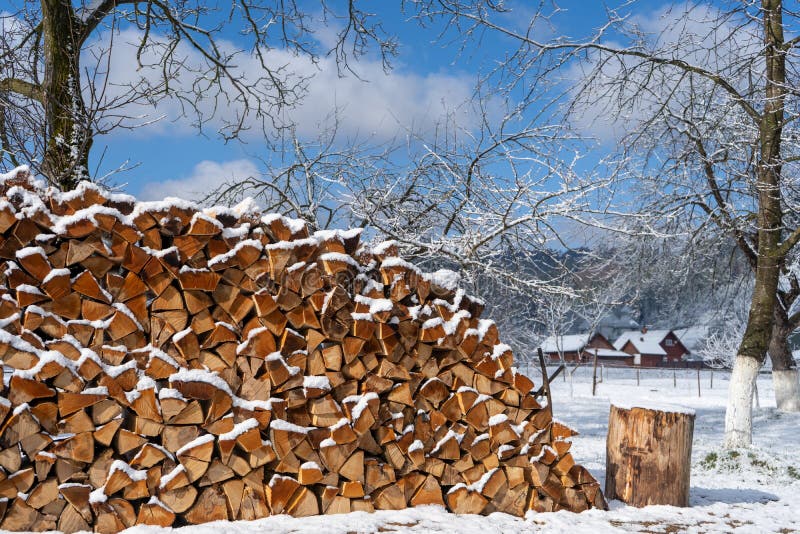 Large Stack of Firewood Piled Outside in the Snow at Sunny Day in ...
