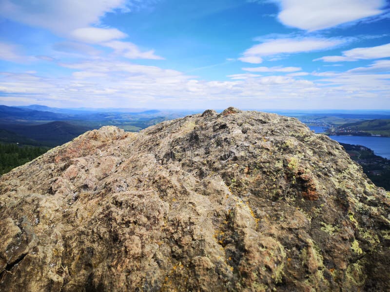 A Large Stone on the Background of Mountains with Trees Stock Photo ...