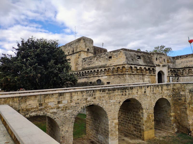 A Large Stone Building Featuring Arches with a Bridge Located in Front ...