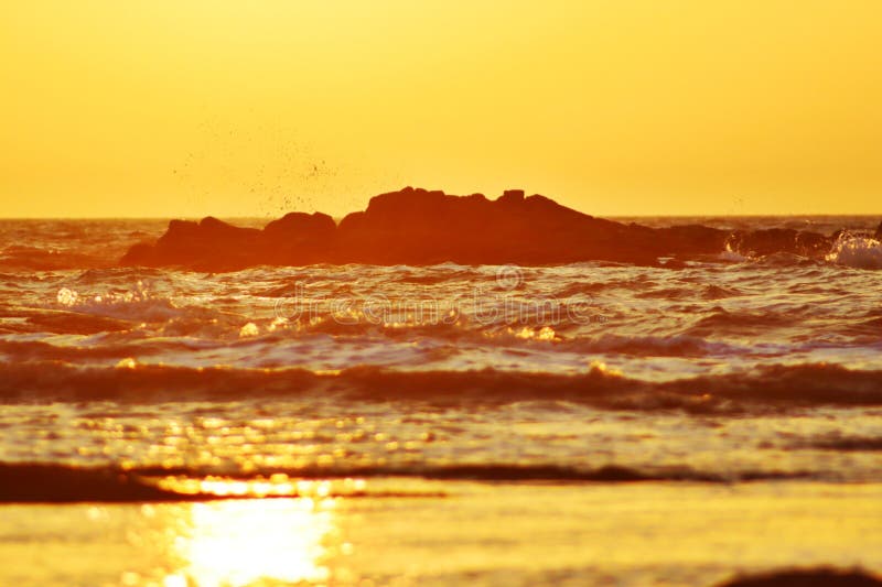 A Large Stone is Sinking in the Sea with Beautiful Sunset Stock Image ...