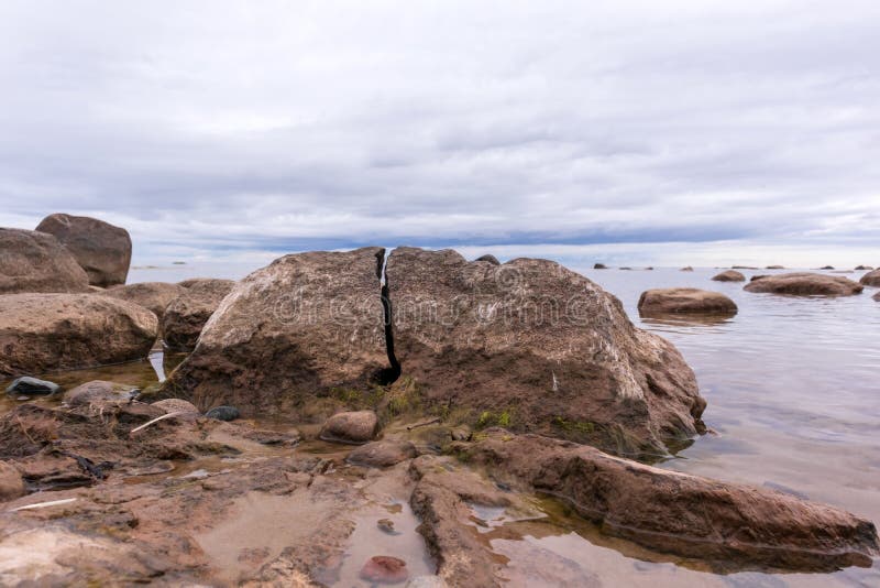 A Large Stone Split in Half Lies by the Sea Stock Photo - Image of ...