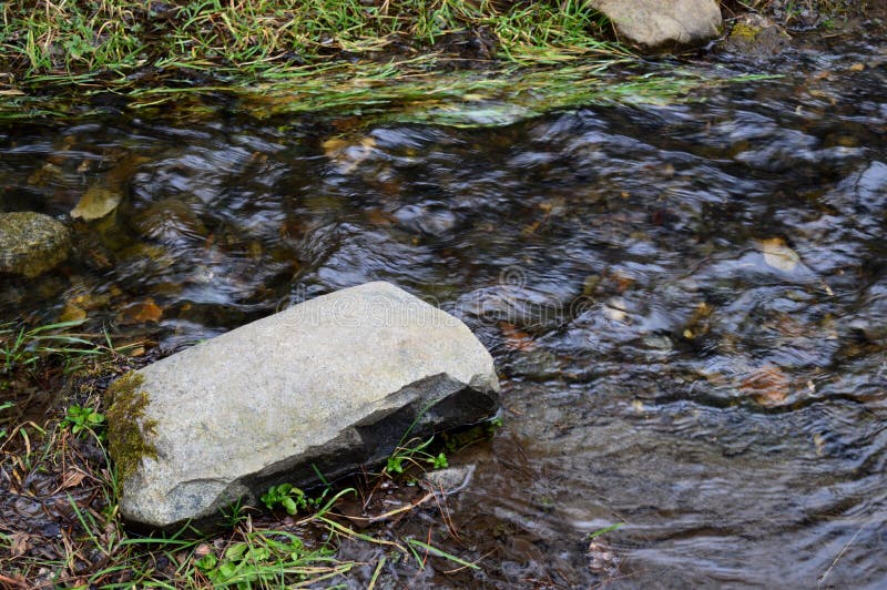 Large stone in a stream stock photo. Image of stone - 212075976