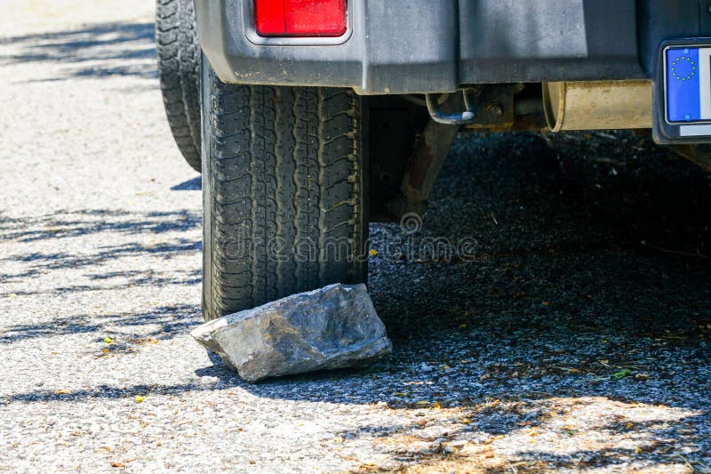 A Large Stone Under the Rear Wheel of the Car Ensures that it Does Not ...