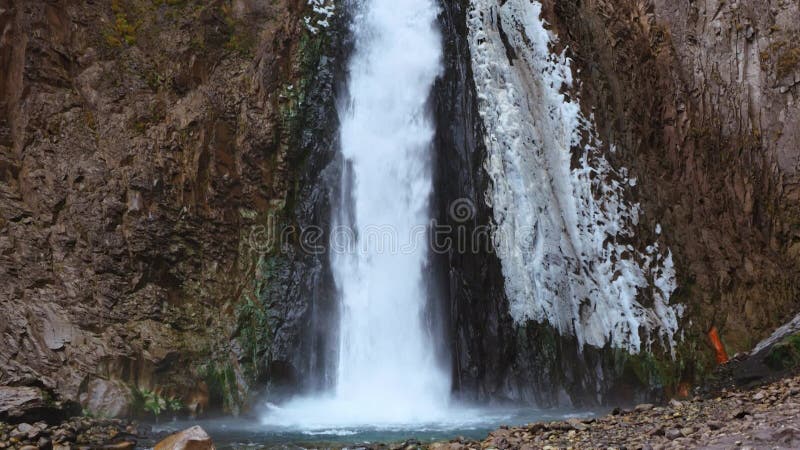 A Large Stream of the Waterfall Falls from a High Cliff. Cold Water ...