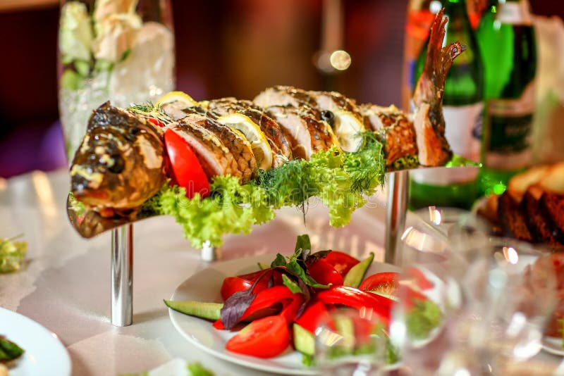 Large Stuffed Fish with Vegetables Decorated Herbs on the Table. Stock ...