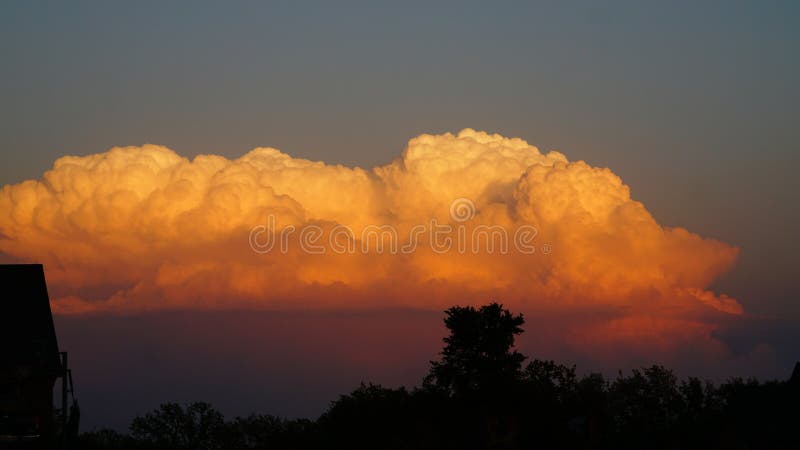 A Large Super Cell Thunderstorm with the Setting Sun on the Clouds ...