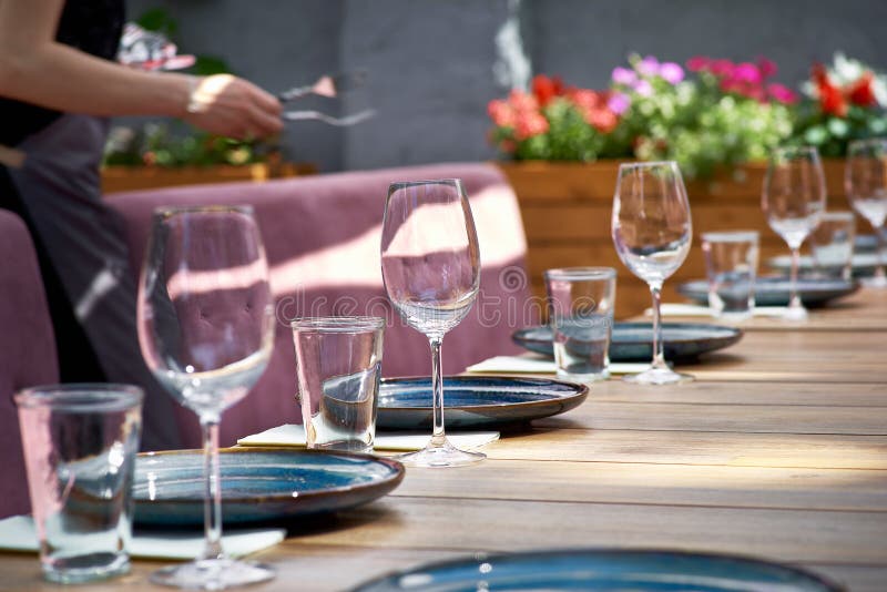 Large Table on the Sun Terrace for Guests. Blue Plates and Glasses on ...
