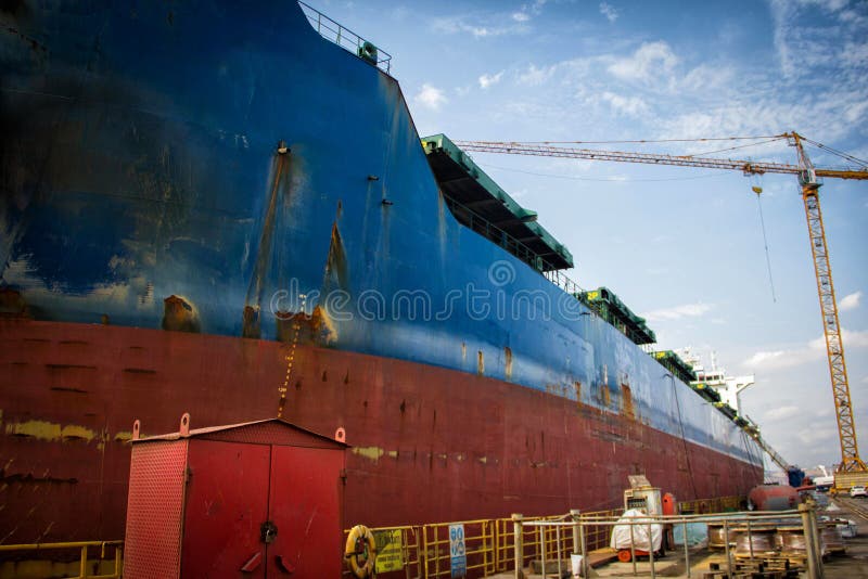 A Large Tanker Cargo Ship is Being Renovated and Painted in Shipyard ...
