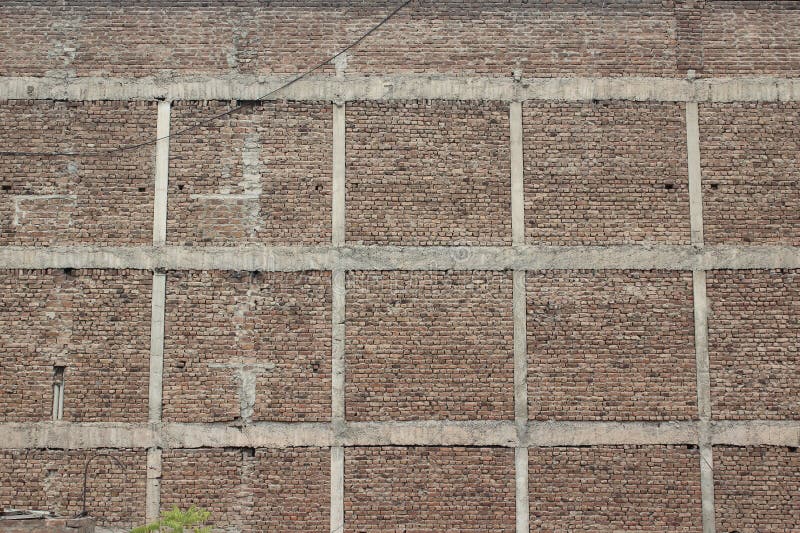 A Large, Unfinished Brick Wall with Visible Concrete Supports Creating ...