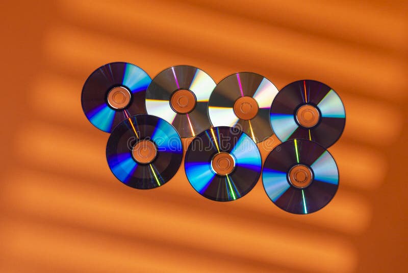 Large Variety of Arranged CD Disks or DVD Disks on Orange Background ...