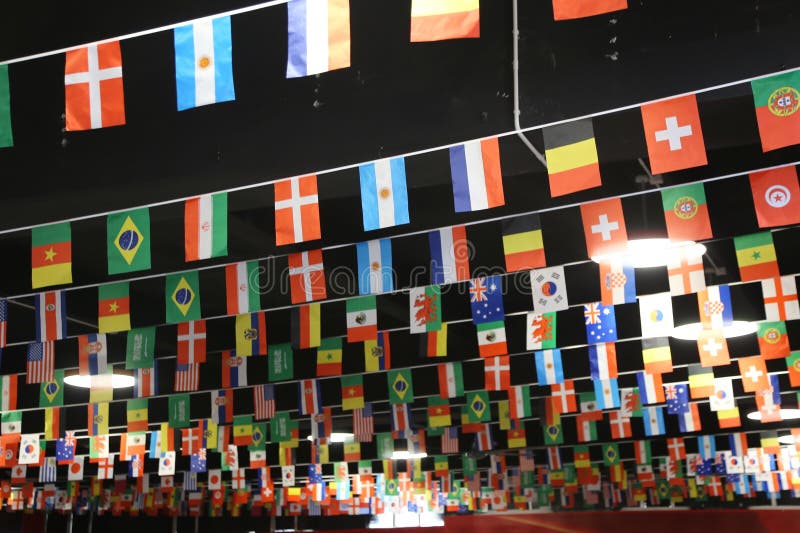 A Large Wall Decorated with Flags of Different Countries, Hanging from ...