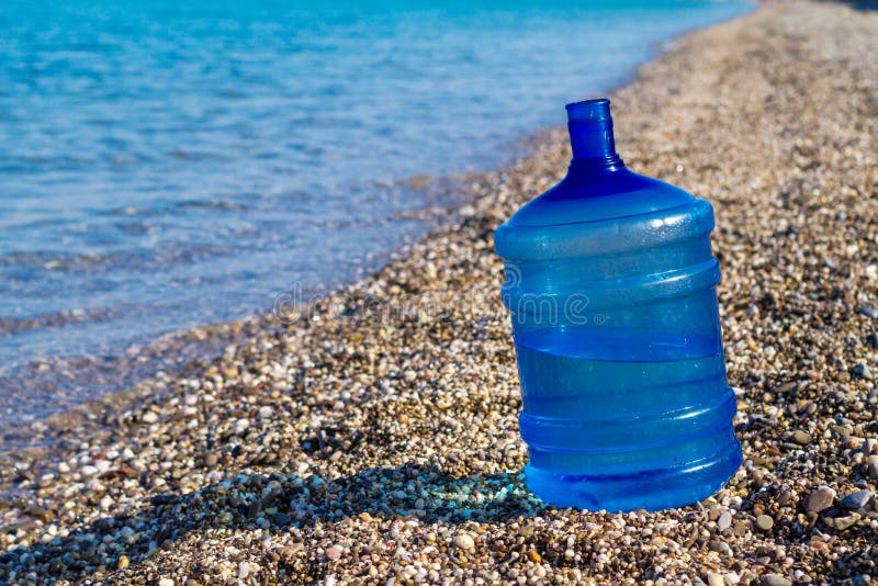 A Large Water Bottle Stands on the Beach, Stock Photo - Image of ...