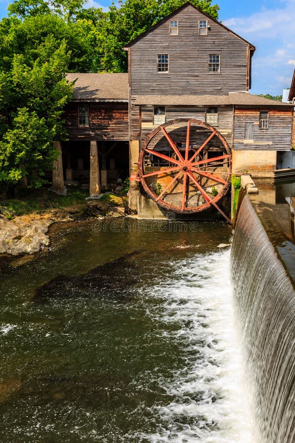 A Large Water Wheel is in the Foreground of a River Stock Image - Image ...
