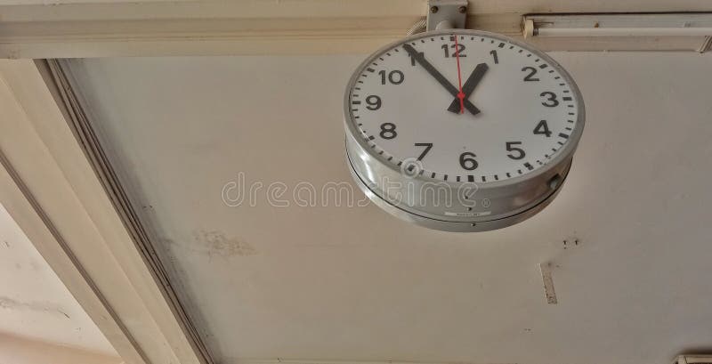 A Large White Analog Clock Hangs from the Ceiling. Stock Photo - Image ...