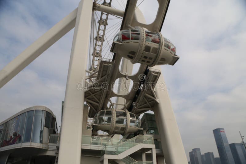 A Large White Ferris Wheel with Two Cars on the Side of it, Suspended ...