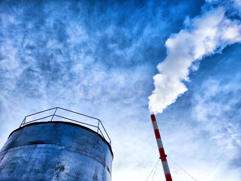 A Large White Plume of Smoke Billows from a Chimney into a Blue Sky ...