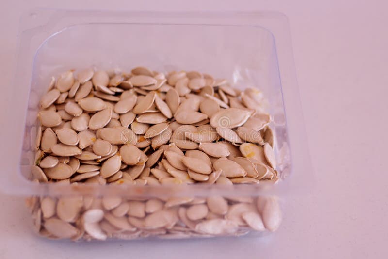 Large White Pumpkin Seeds in a Transparent Plastic Box on a Light ...