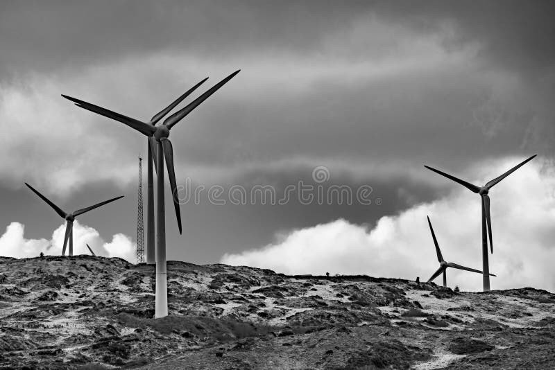 A Large Wind Turbine Dominates the Landscape, Its Blades Casting Long ...