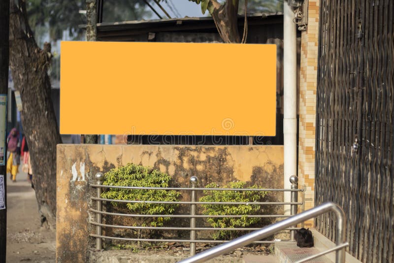 A Large Yellow Blank Signboard Over a Small Garden and the Background ...