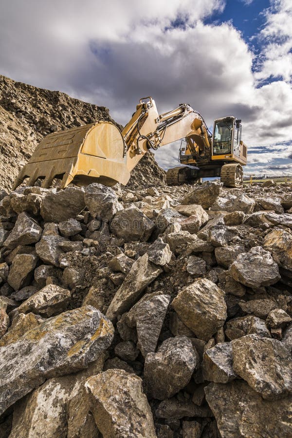 A Large Yellow Excavator Moving Stone in a Quarry Stock Image - Image ...