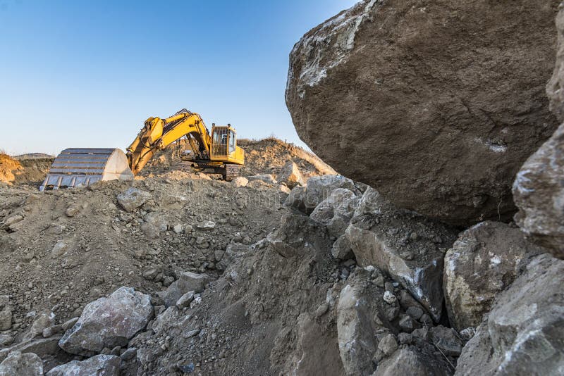 A Large Yellow Excavator Moving Stone in a Quarry Stock Photo - Image ...