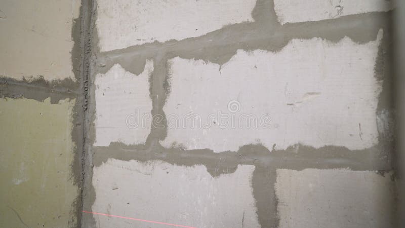 Laser Level Tool Projecting Red Beam Onto White Brick Wall during ...