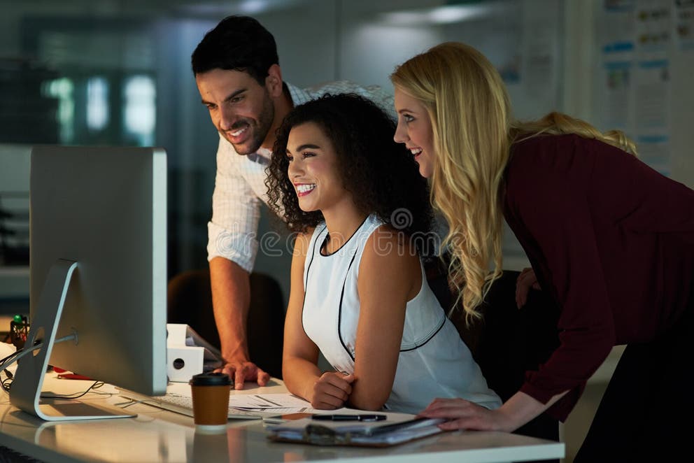 Late Night Collaborations. a Group of Young Colleagues Using a Computer ...