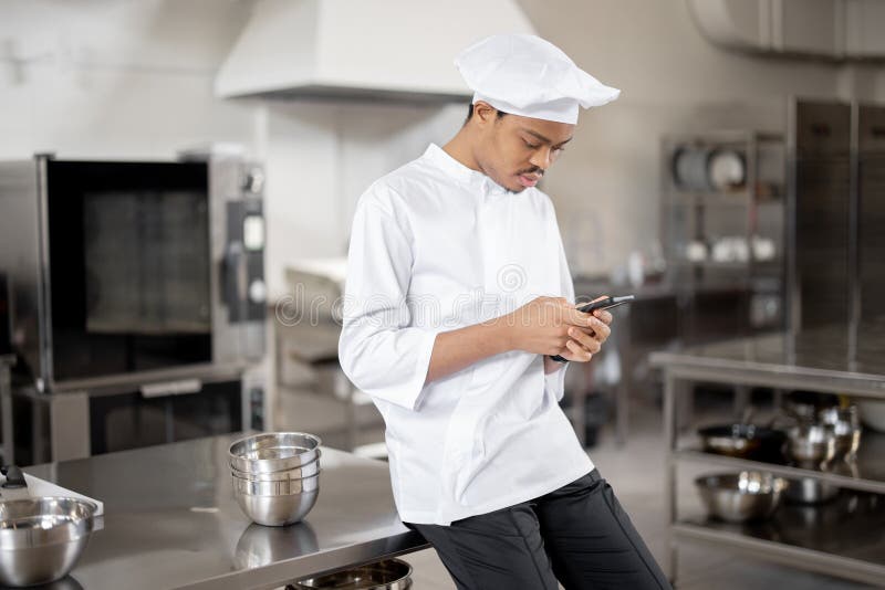 Latin Chef with Phone in Professional Restaurant Kitchen Stock Image ...
