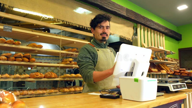 Salesman Using Computer Stranding at Counter of a Bakery Shop Stock ...